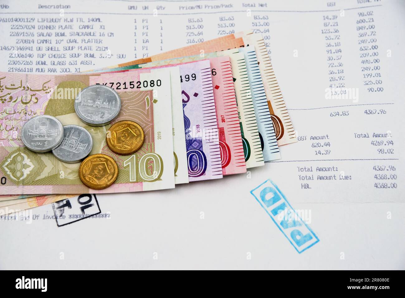 Currency notes in Pakistani Rupees with a paid invoice Stock Photo - Alamy