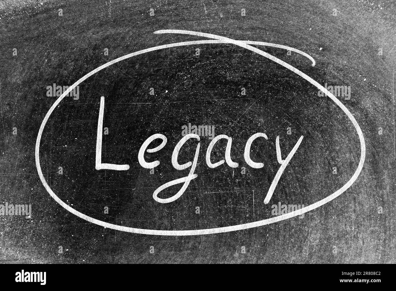 White chalk hand writing in word legacy and circle shape on blackboard ...