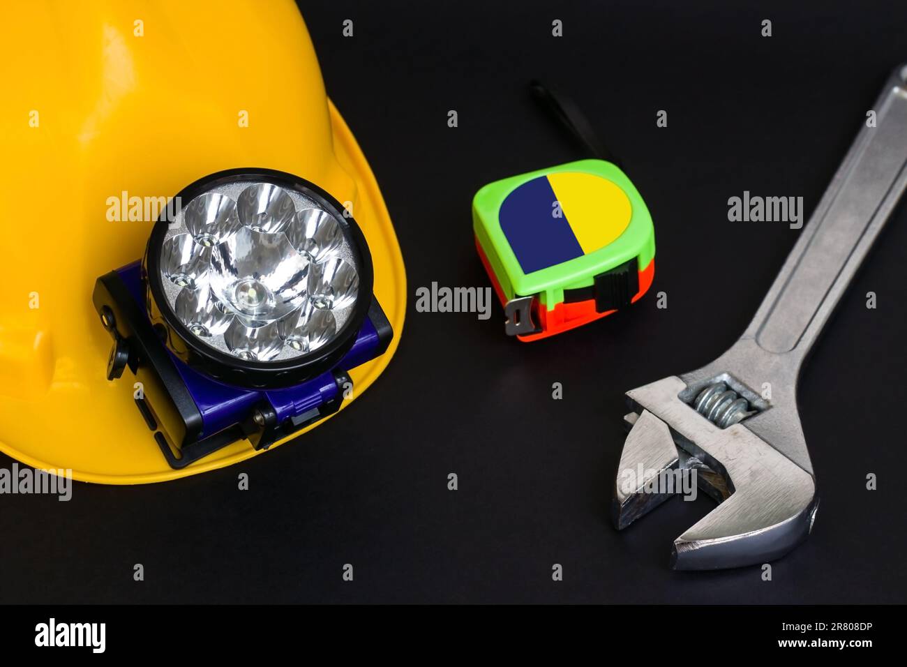 Yellow color hard hat,helmet,overhead light,tape measure and wrench on ...