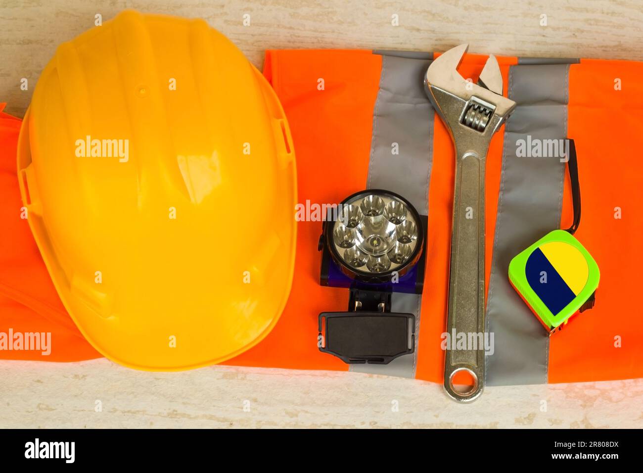 Yellow color hard hat,helmet,overhead light,tape measure and wrench on ...