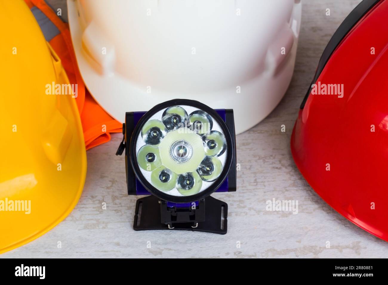 Red, yellow and white colored helmets with rechargeable helmet light on ...