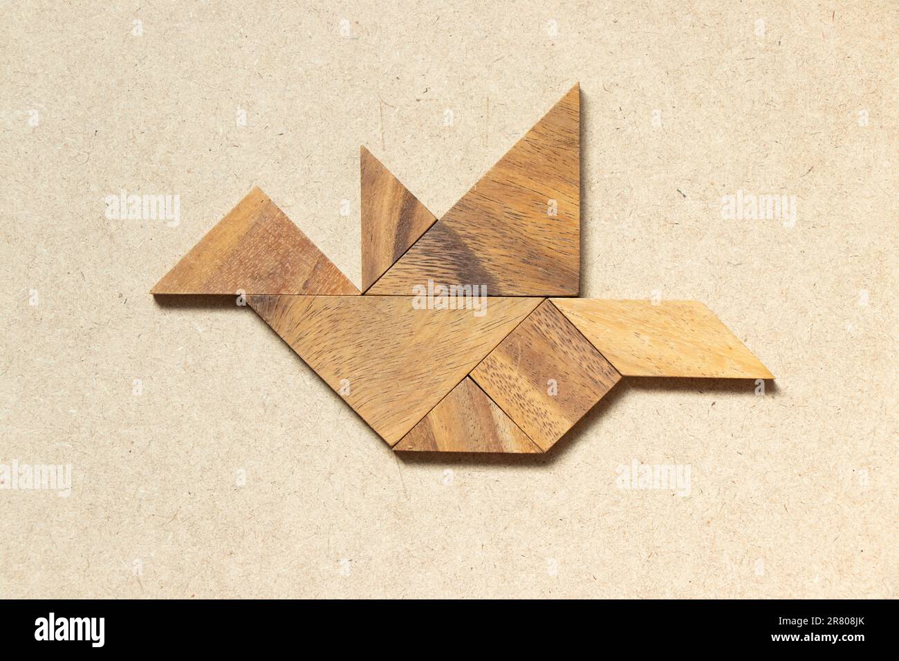 Wooden tangram in flying bird shape on wood background Stock Photo - Alamy