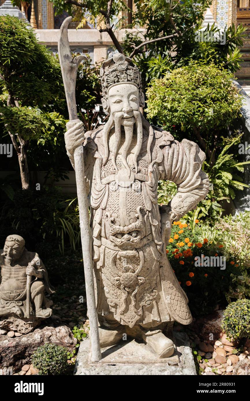 A bronze statue of an ancient Chinese deity, standing atop a pedestal ...