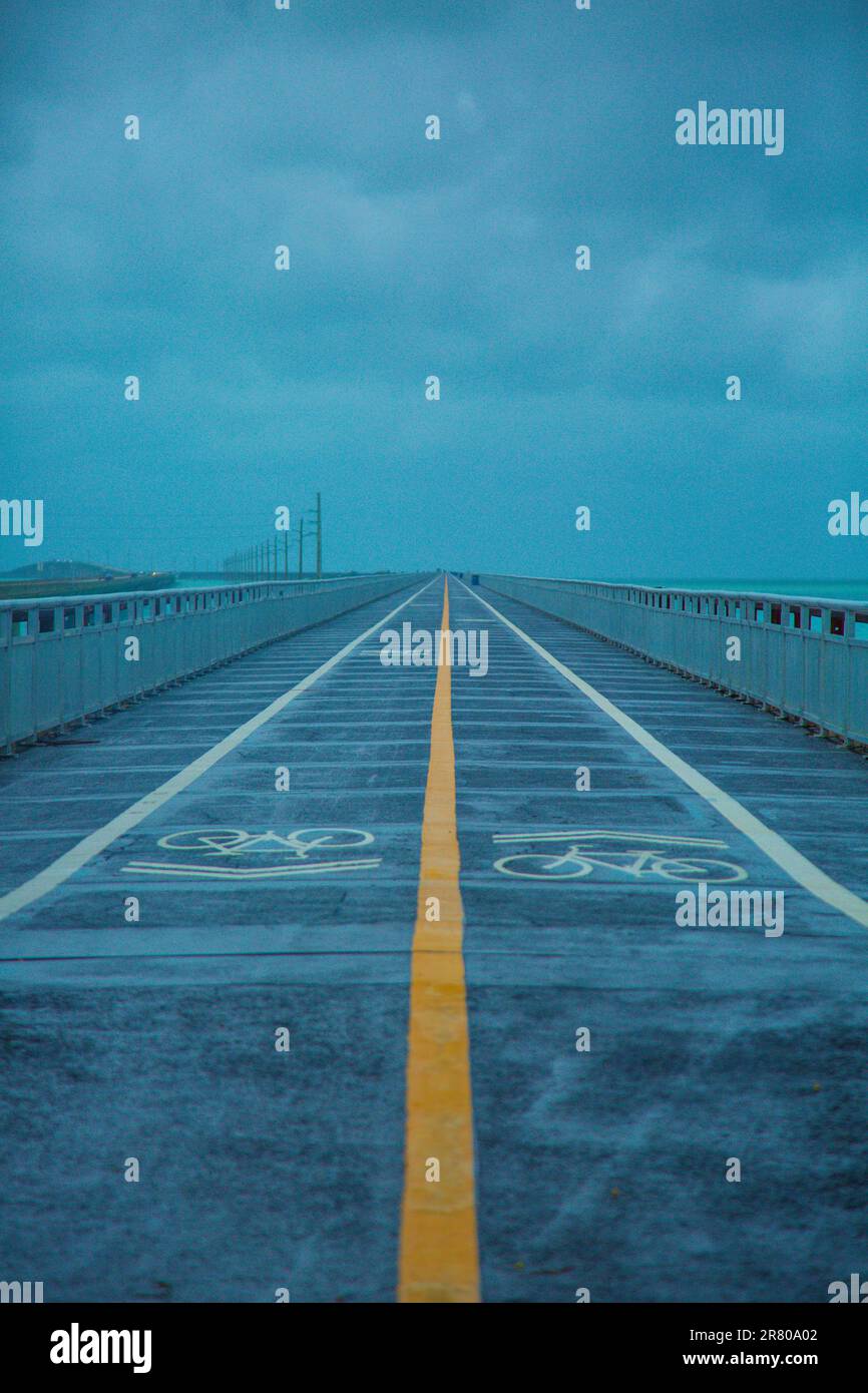 A vibrant yellow roadway stretches across a vast parking lot, crossing ...