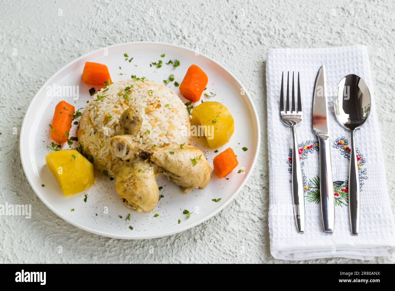 Boiled chicken legs and vegetables designed on a white plate with ...