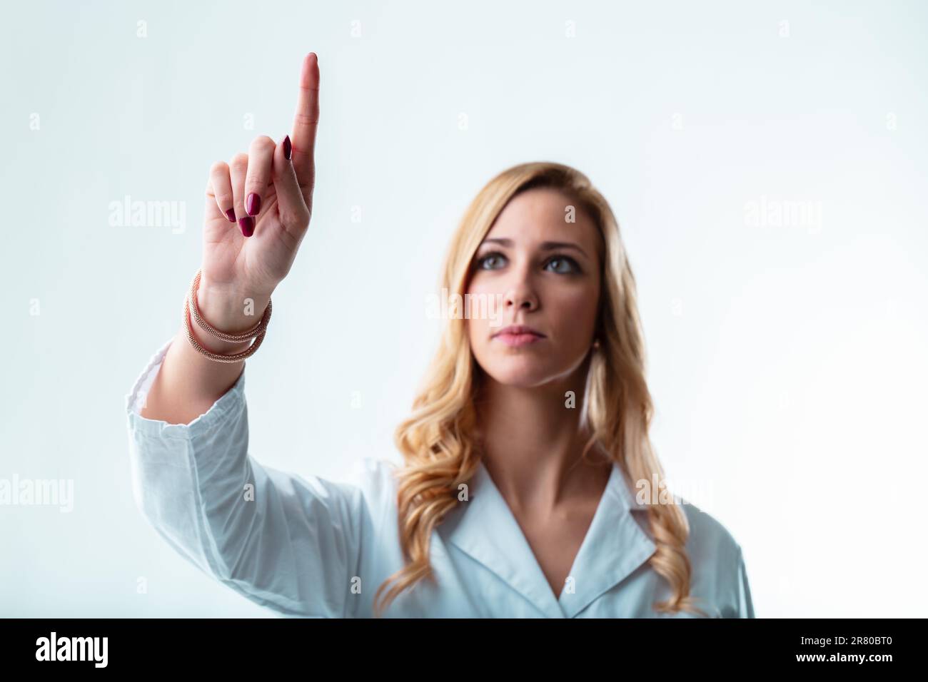 Woman in white, blurred, typing in air where you'll place your floating ...