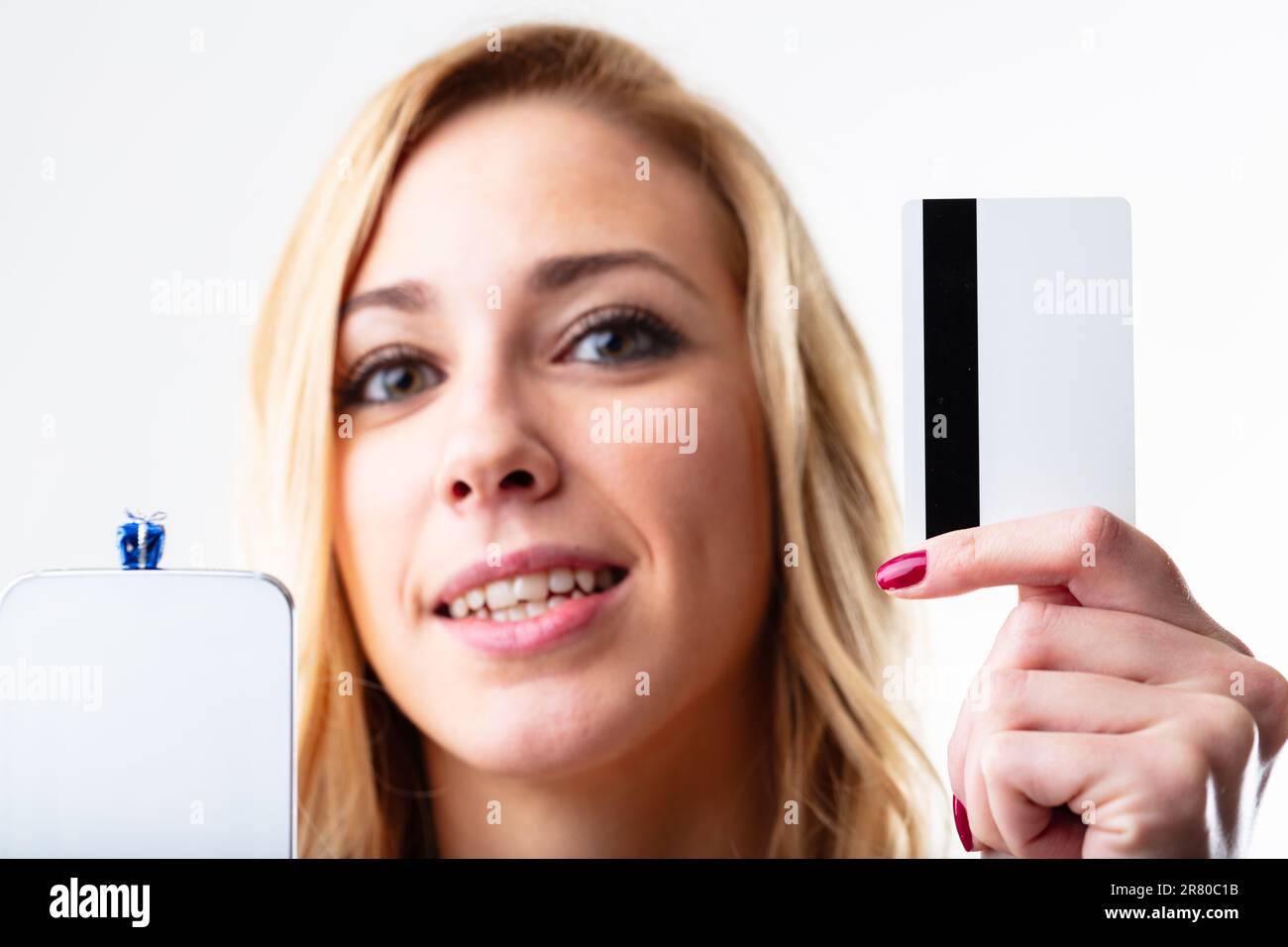 'Blonde woman, smartphone, credit card, gift package representing the joy of online shopping ...