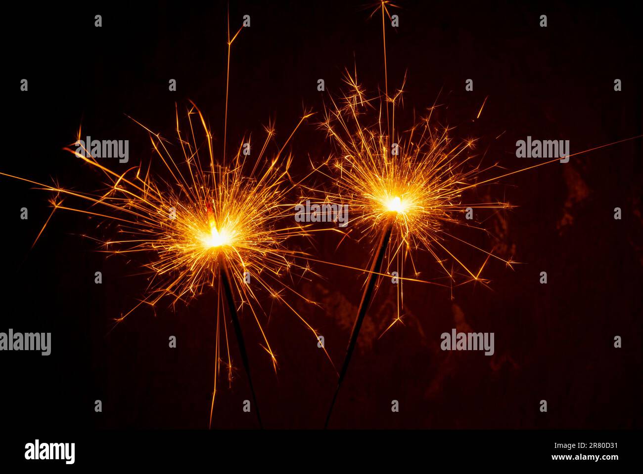 Bright burning sparklers on the dark background Stock Photo - Alamy
