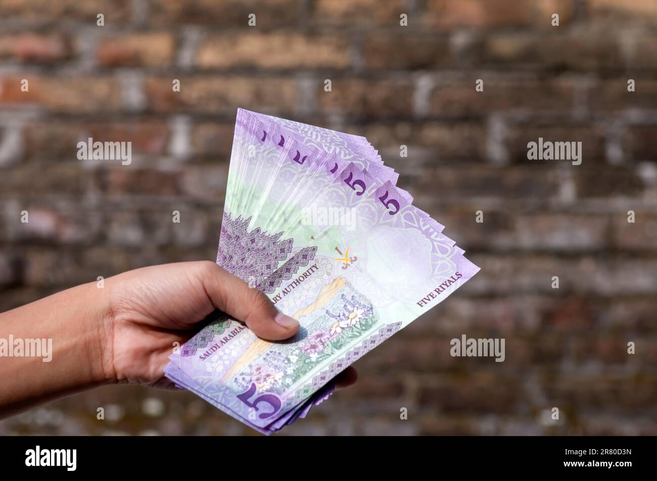 Asian children hand with five Riyal, the currency of Saudi Arabia ...