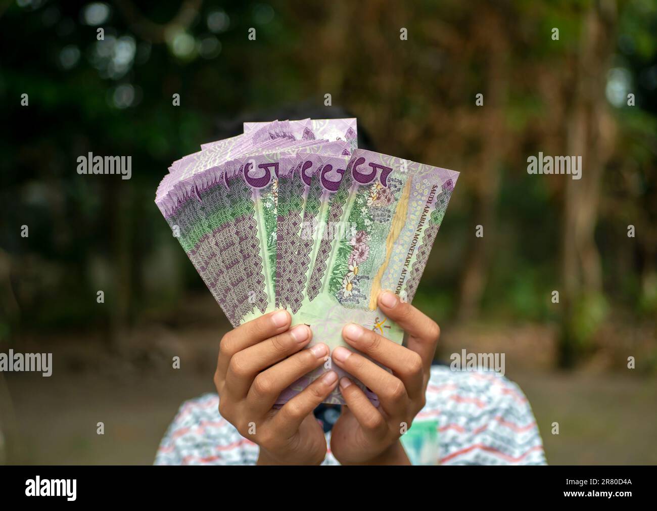 Asian children hand with five Riyal, the currency of Saudi Arabia ...