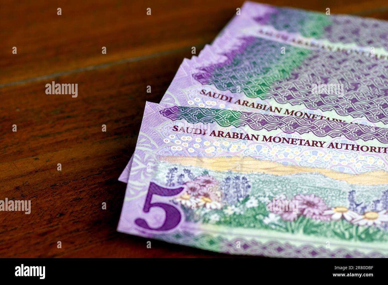A pile of Saudi Arabia five riyals banknotes money on wooden table ...