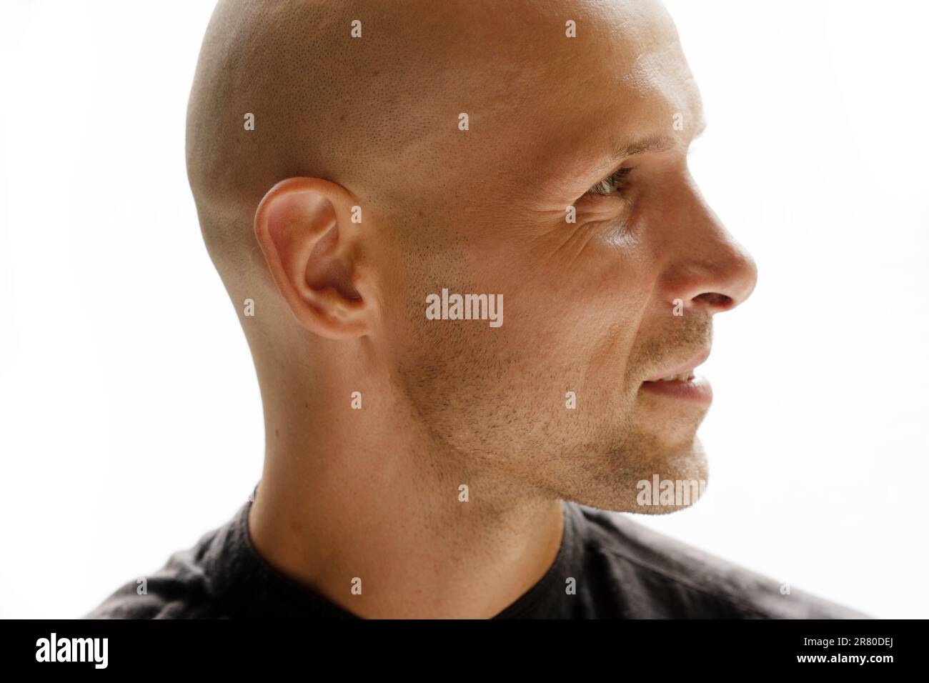 A profile portrait of a bald man half smiling Stock Photo - Alamy