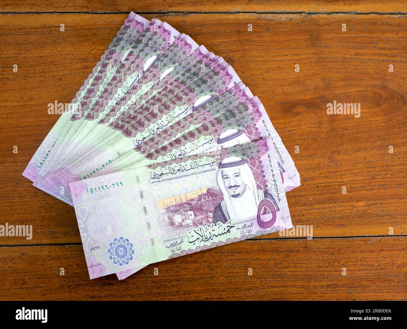 A pile of Saudi Arabia five riyals banknotes money on wooden table ...