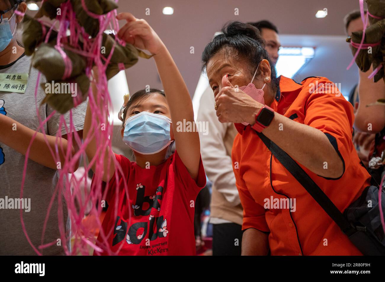 Kuala Lumpur, Malaysia. 18th June, 2023. A child learns to wrap Zongzi ...