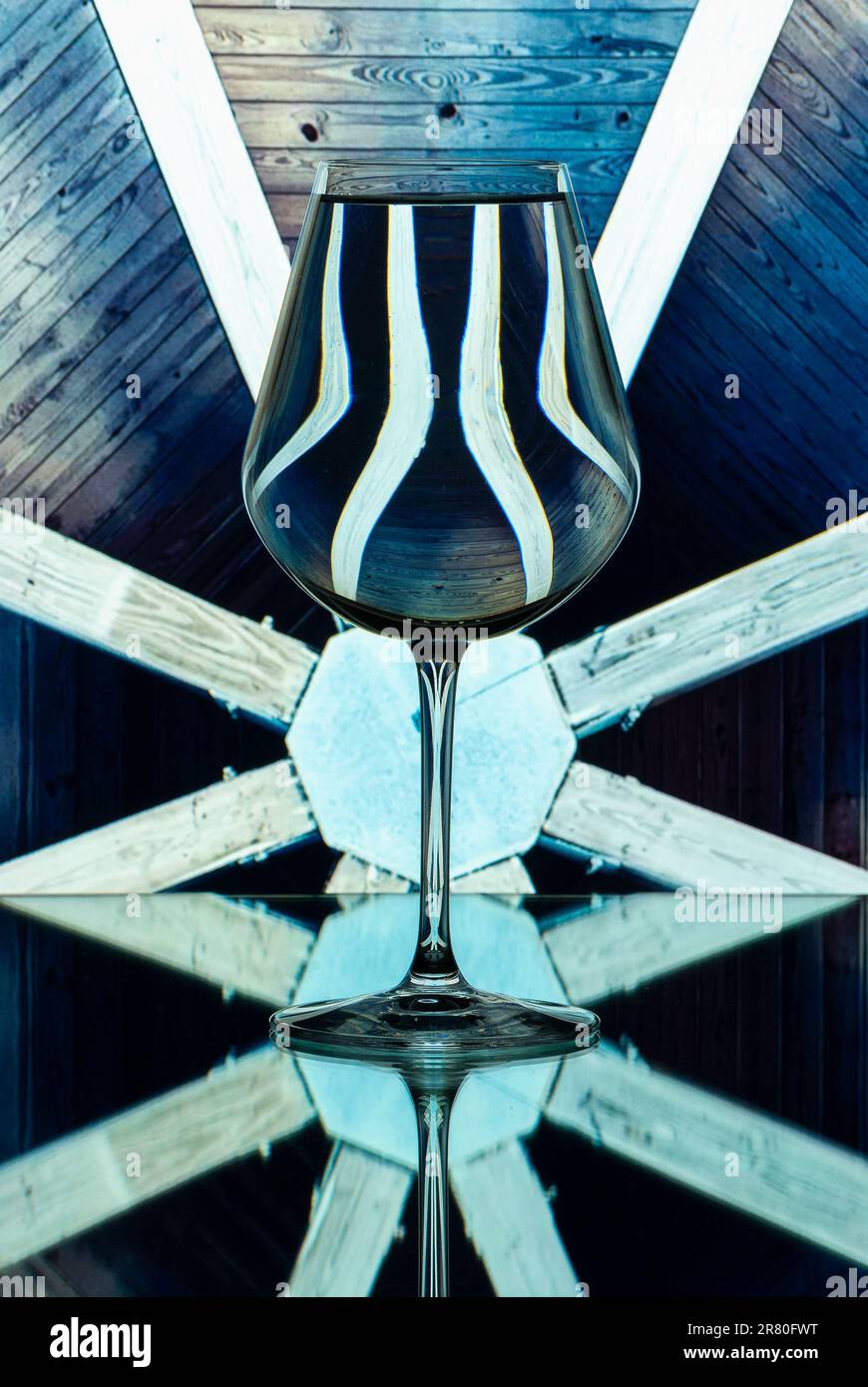 Glass of water against a striped background to illustrate the effect of ...