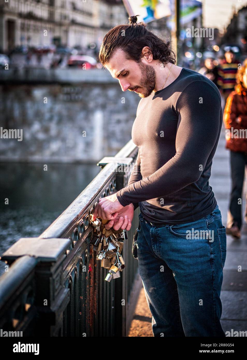 Man attaching lock on bridge during walk Stock Photo - Alamy