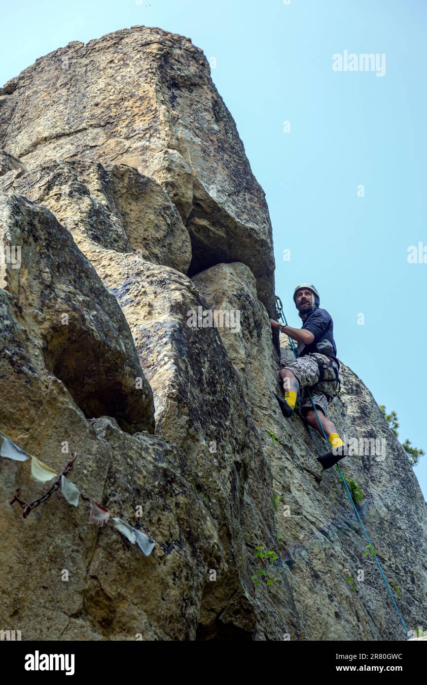 Risk and Determination: A man climbs a rock formation formation with ...