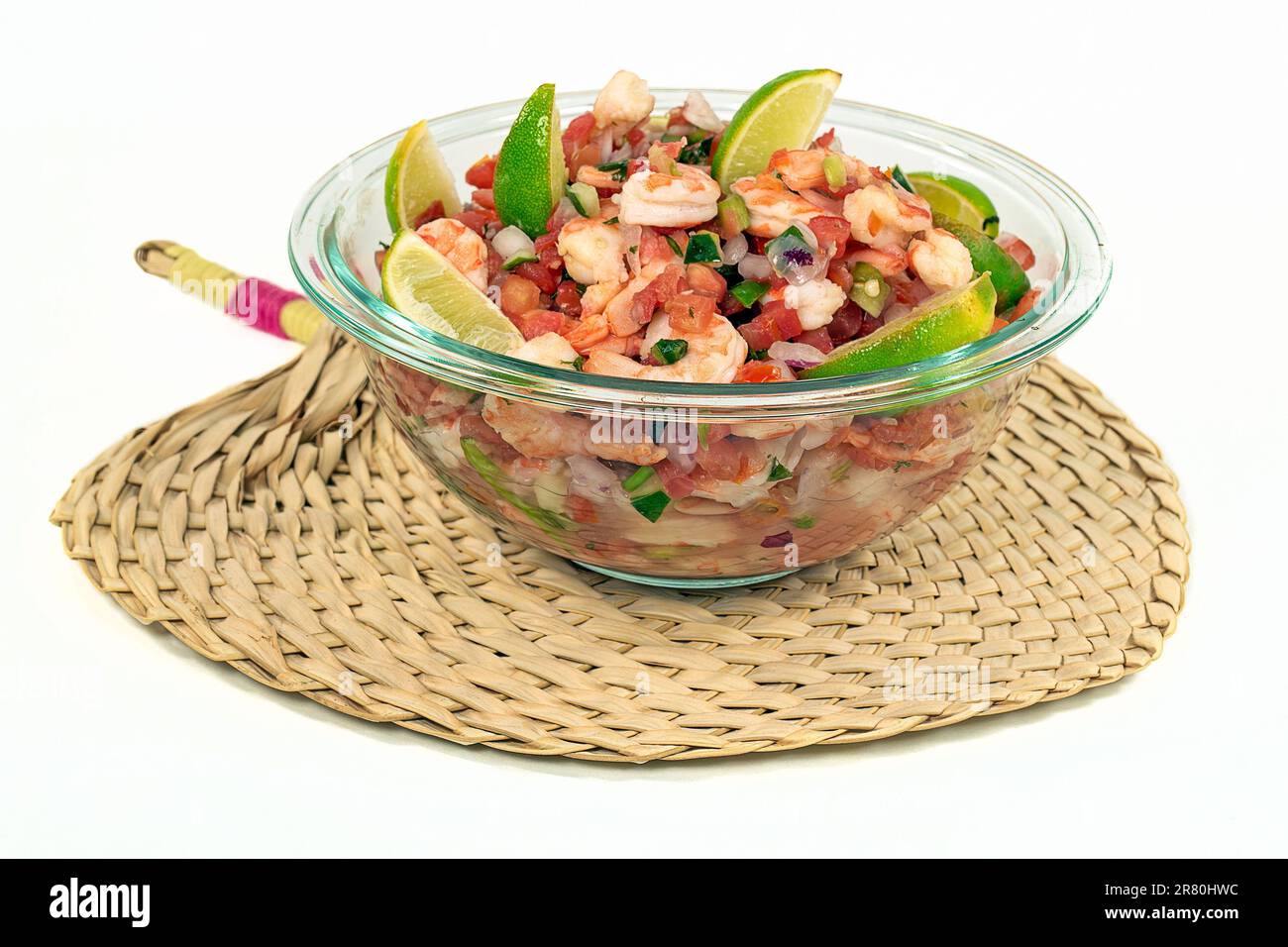 Fresh shrimp salad with lime slices in a glass bowl on a bamboo mat ...