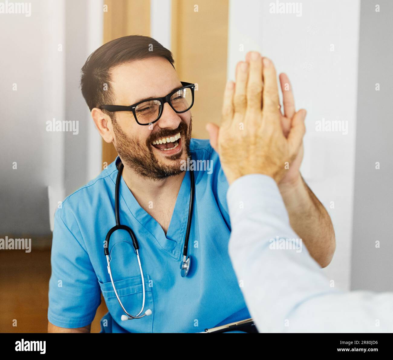 Doctor or nurse caregiver with senior man giving high five at home or ...
