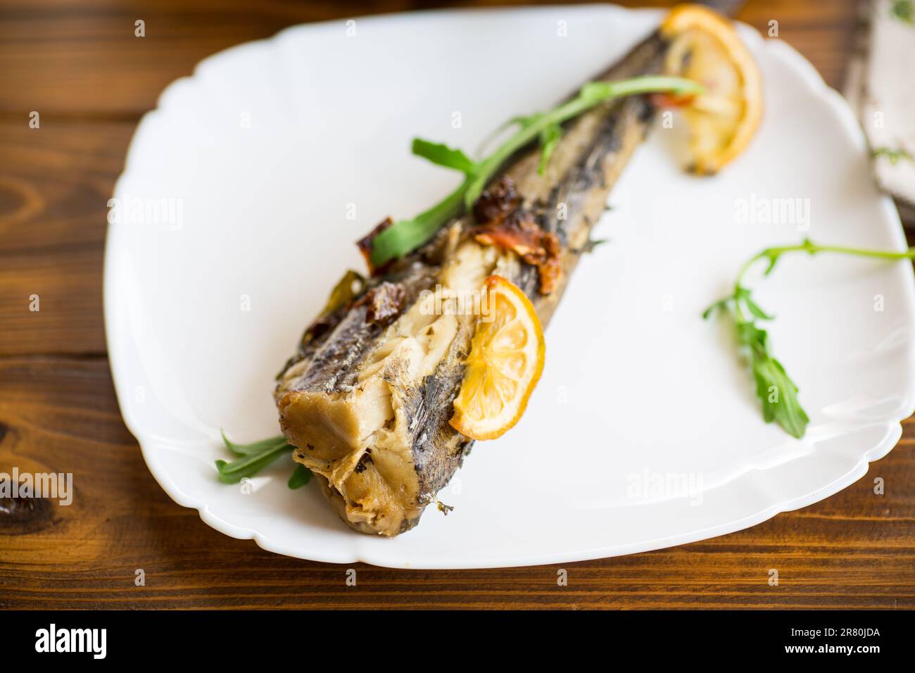 Baked fish with seasonings and spices in a plate Stock Photo - Alamy