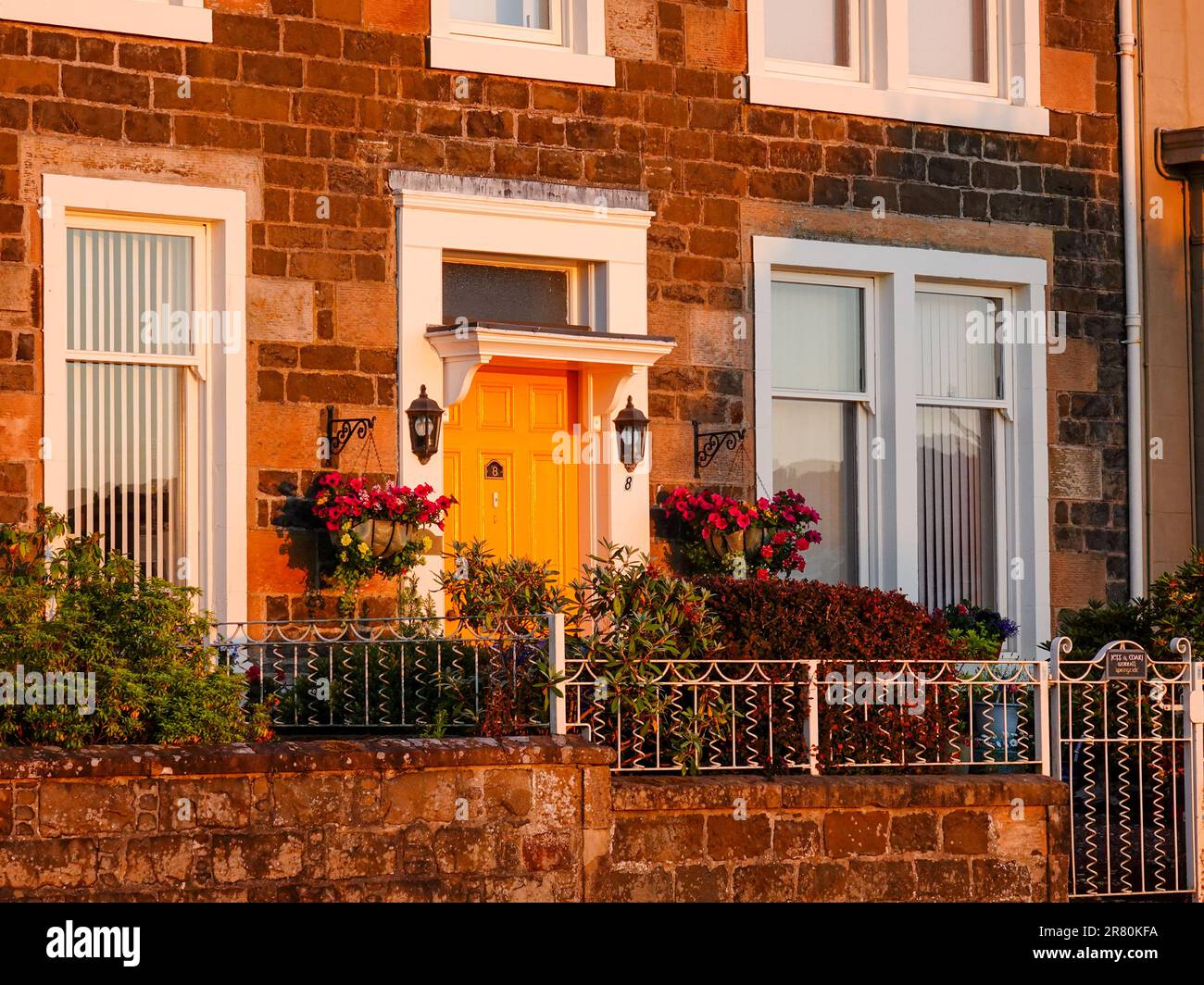Brick residential building with yellow front door, at sunset, Rothesay ...