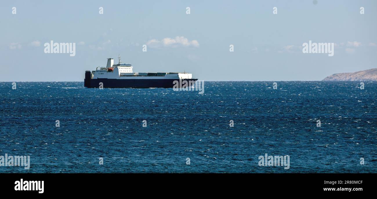 Tinos island, Cyclades, destination Greece. Container cargo ship loaded ...