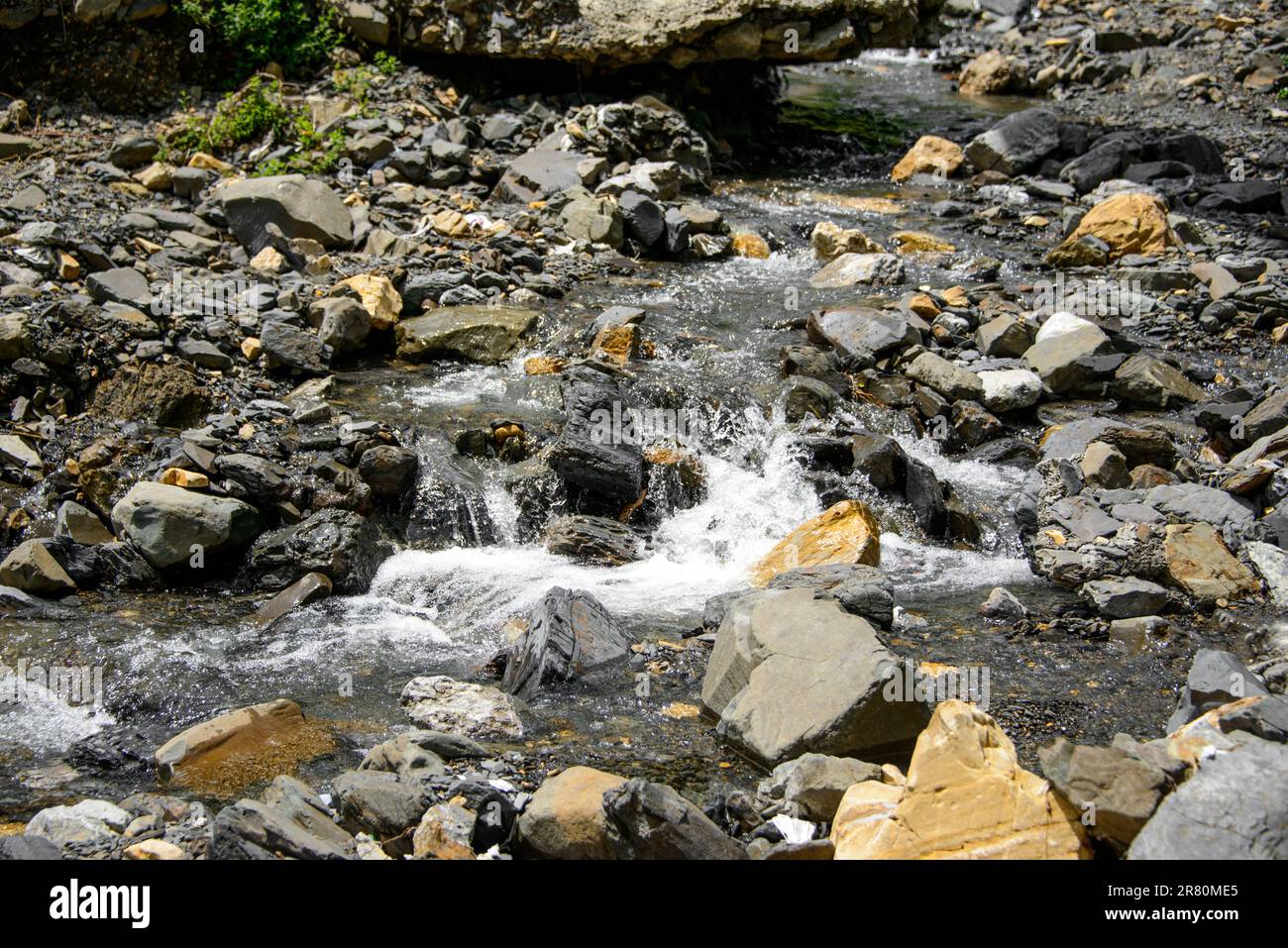 Water flowing over river rocks near mountains in Nathia Gali ...