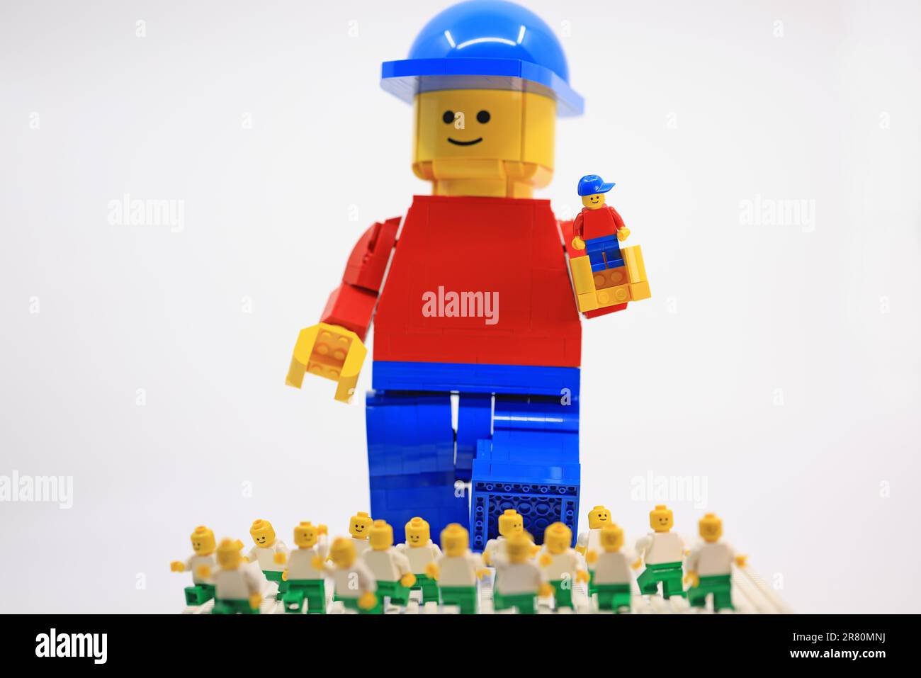 giant man support the mini one and pick him up from the crowd Stock ...