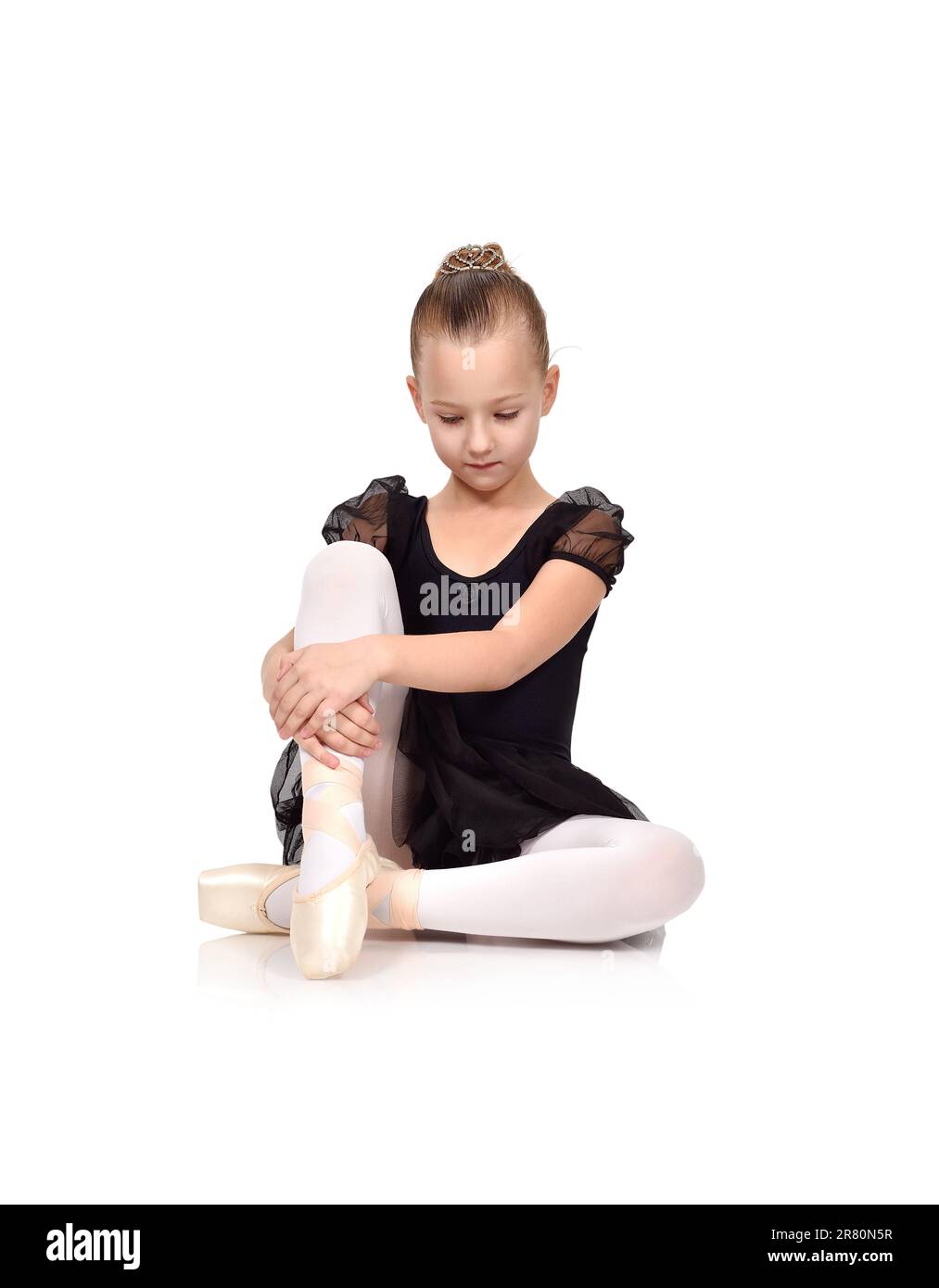 Girl ballerina sitting on floor on white background Stock Photo - Alamy