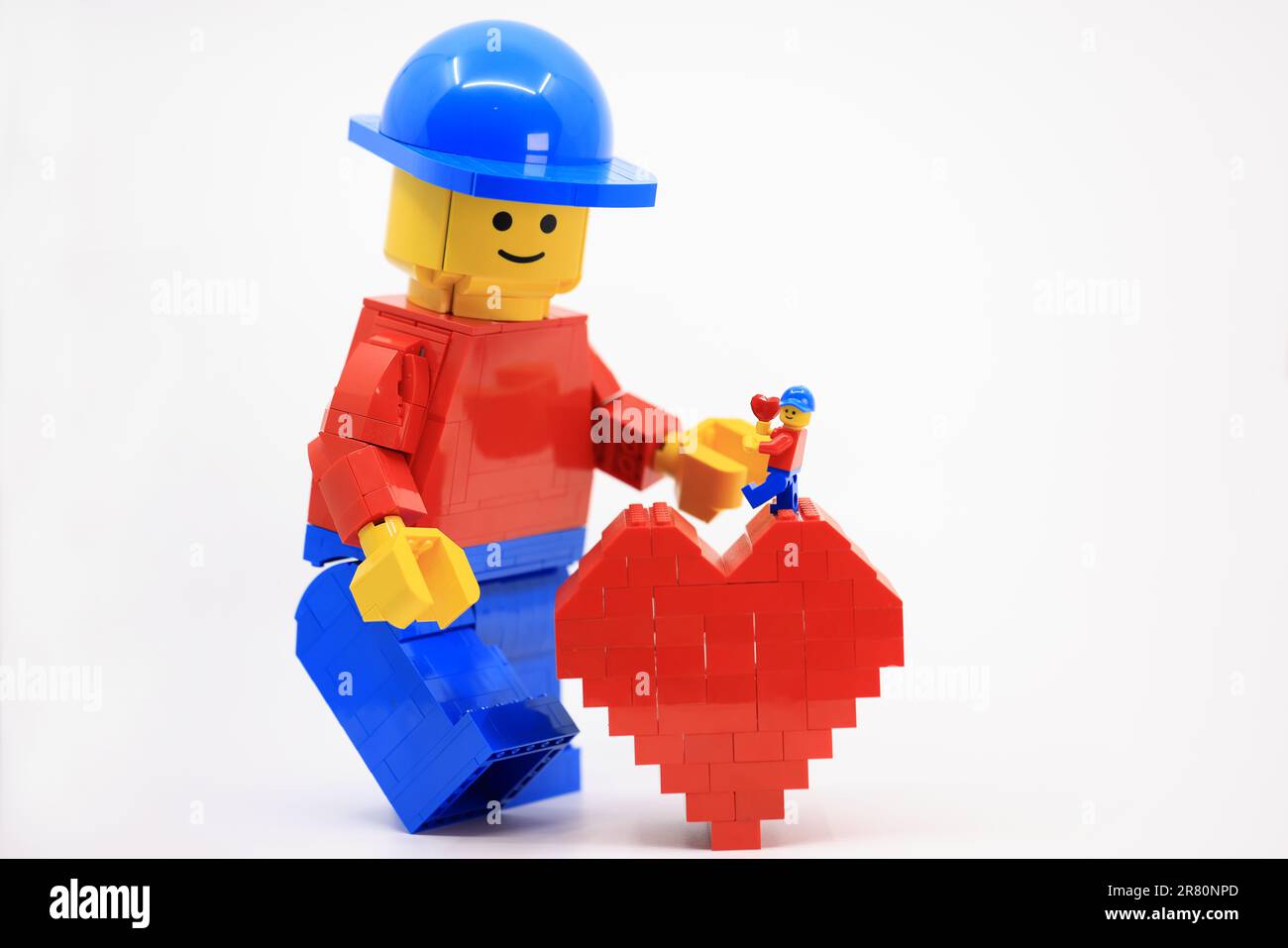 giant man pick up small one which holding they also hold a heart Stock ...