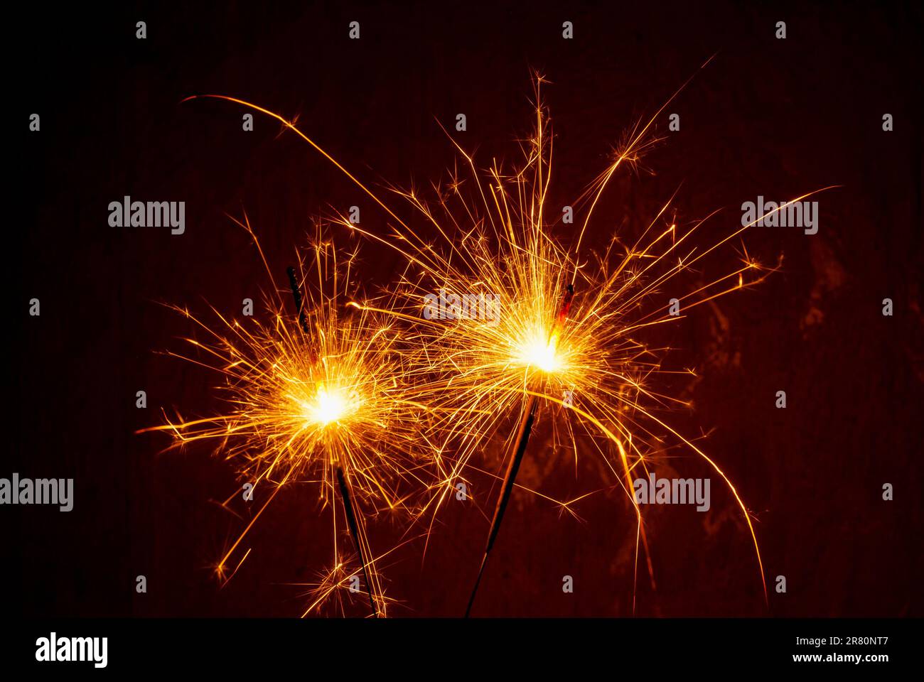 Bright burning sparklers on the dark background Stock Photo - Alamy