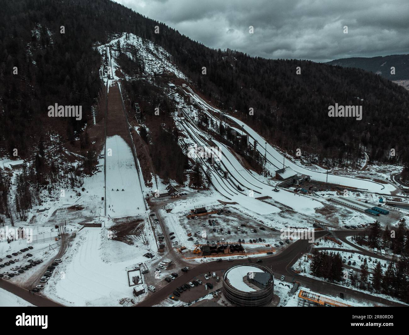 An aerial view of a downhill ski resort in the snowy terrain in Planica ...