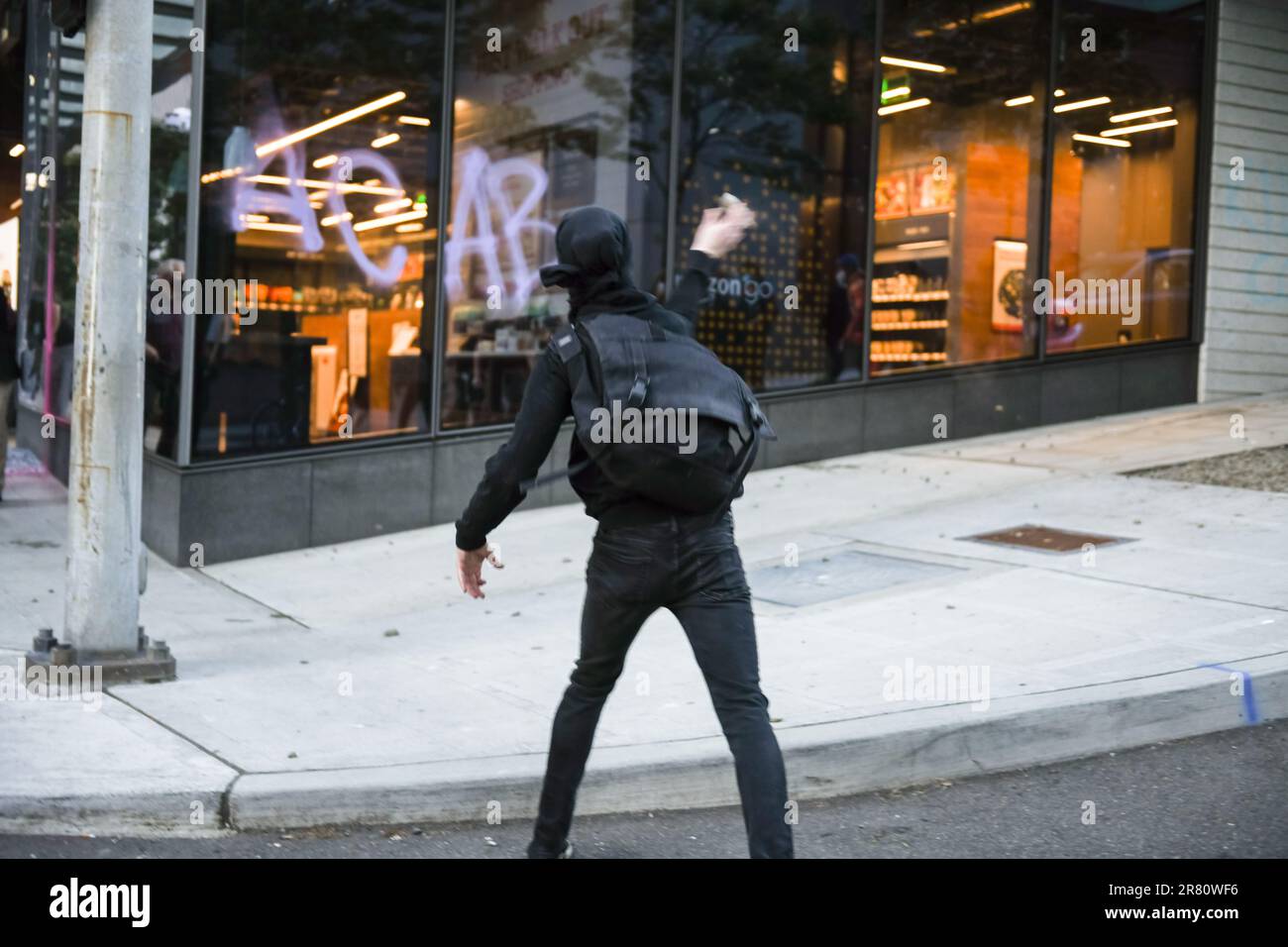 Seattle, USA. 29 May, 2020. A protestor throwing a rock at the Amazon ...