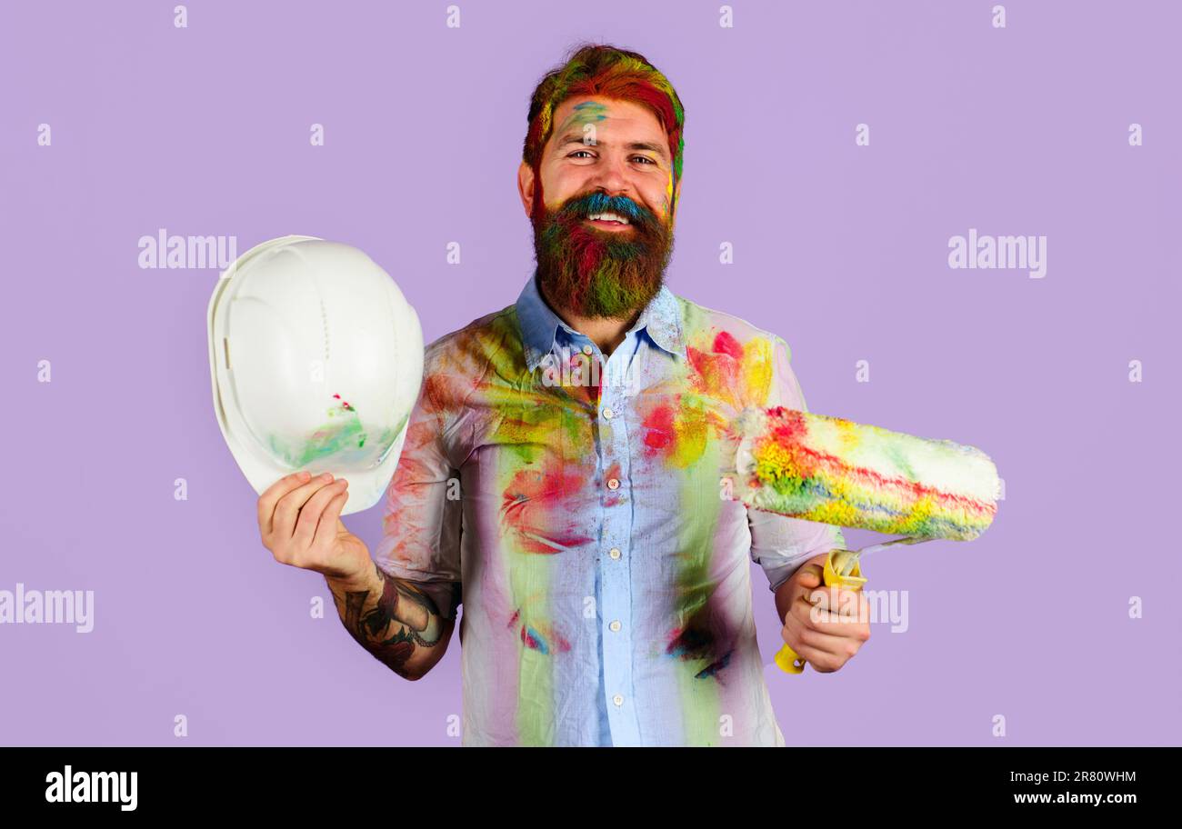 Smiling painter or decorator with paint roller and hard hat. Repairman ...
