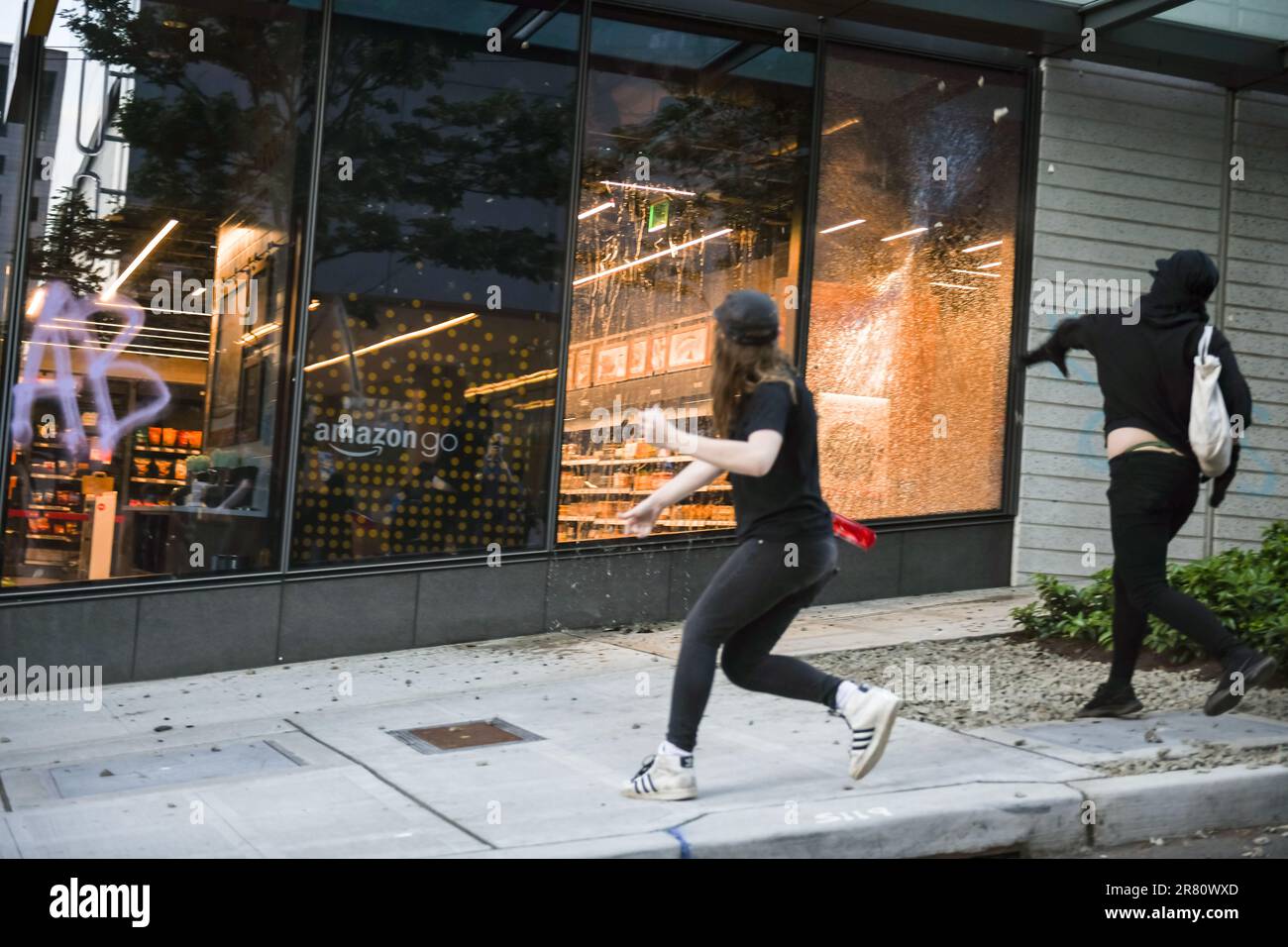 Seattle, USA. 29 May, 2020. A protestor throwing a rock at the Amazon ...