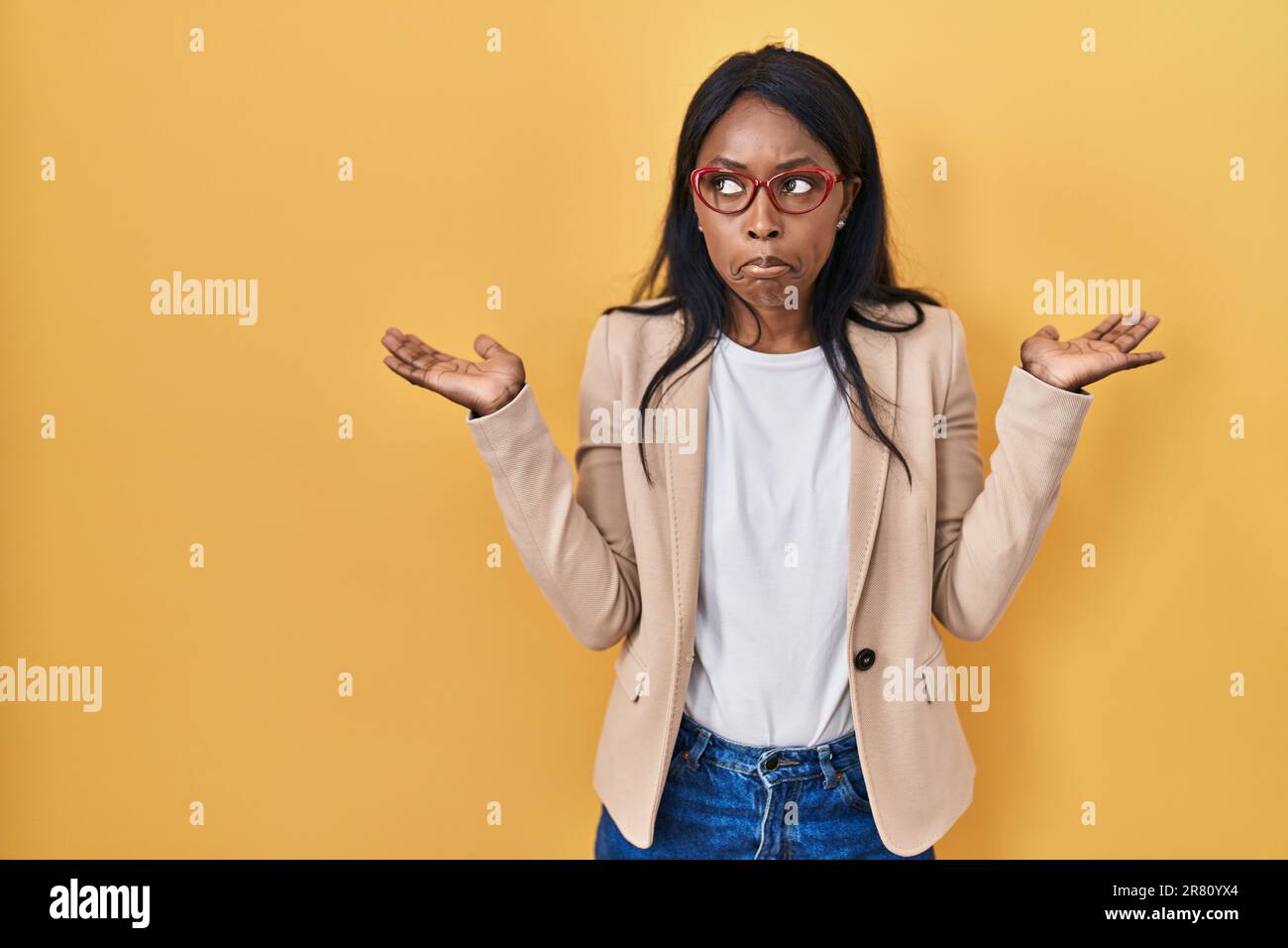 African young woman wearing glasses clueless and confused expression ...