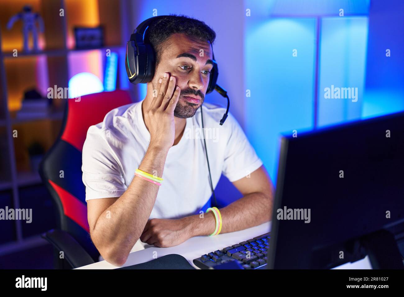 Young hispanic man streamer stressed using computer at gaming room ...