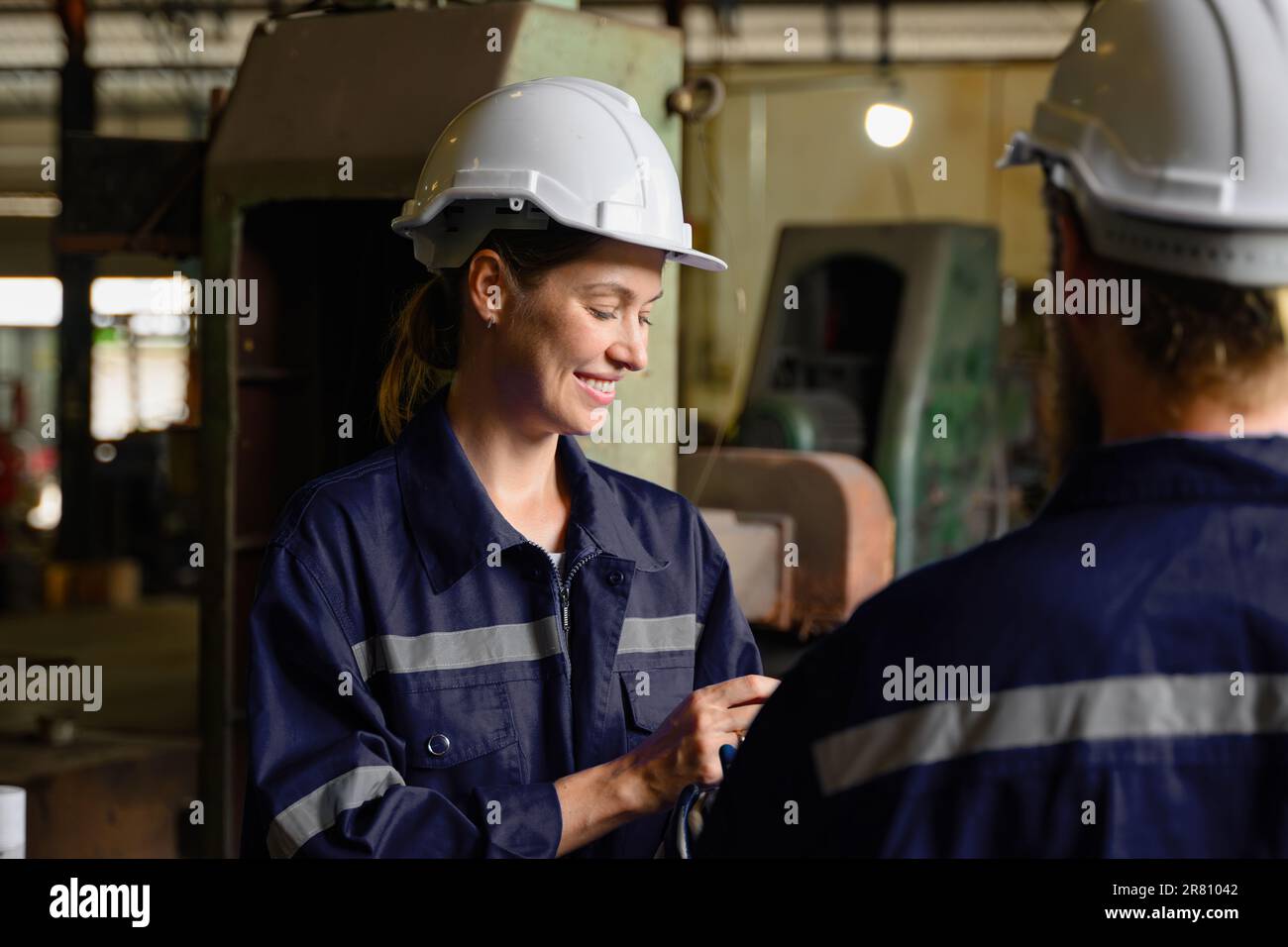 Mechanical engineers repairing engine machine at factory Stock Photo ...