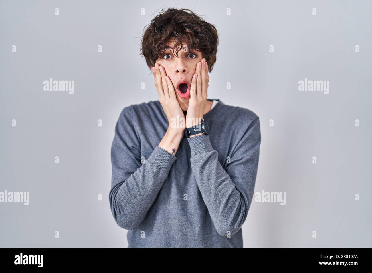 Young man standing over isolated background afraid and shocked ...