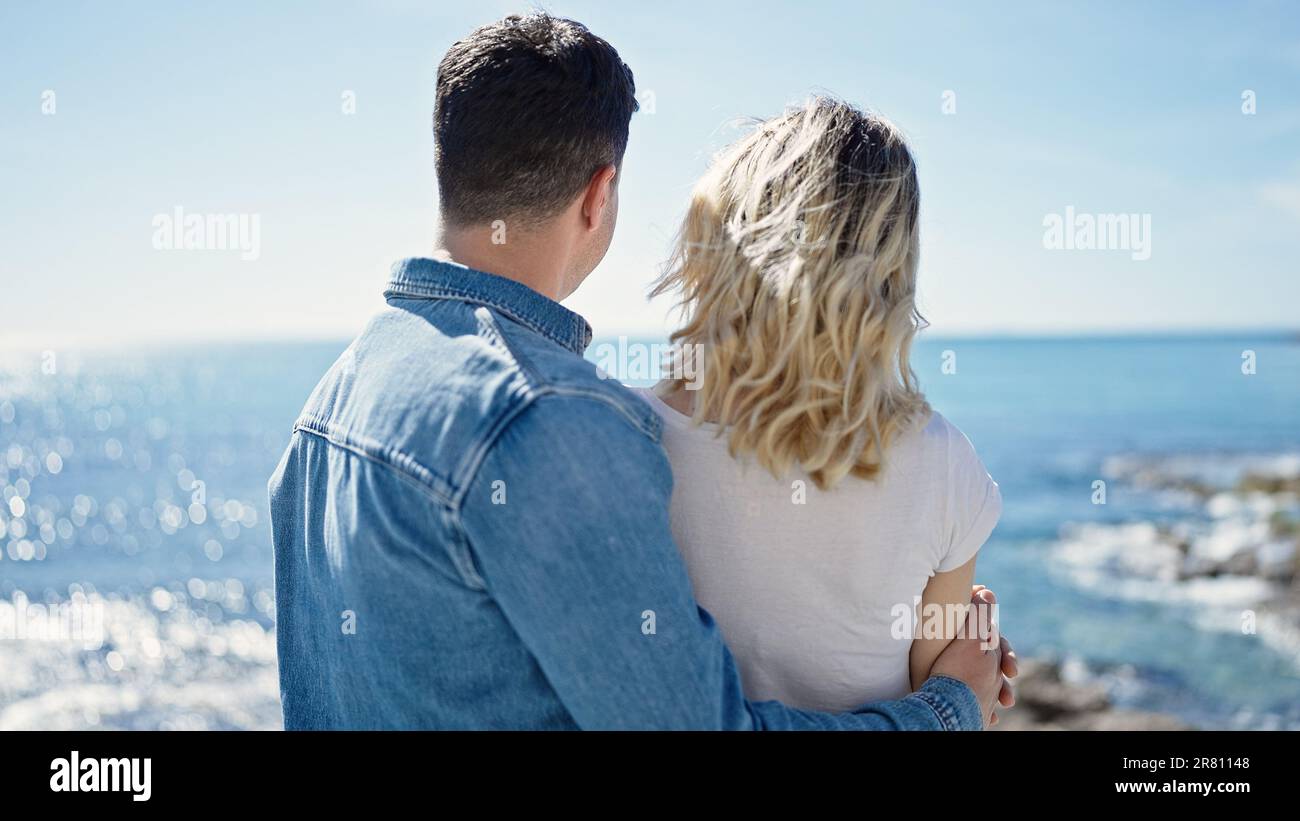 Man and woman couple hugging each other backwards at seaside Stock ...