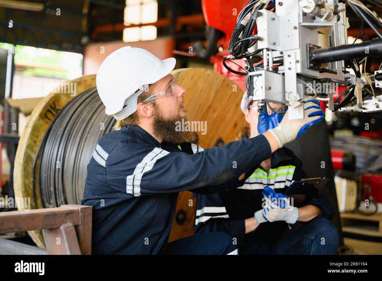 Mechanical engineers repairing engine machine at factory Stock Photo ...