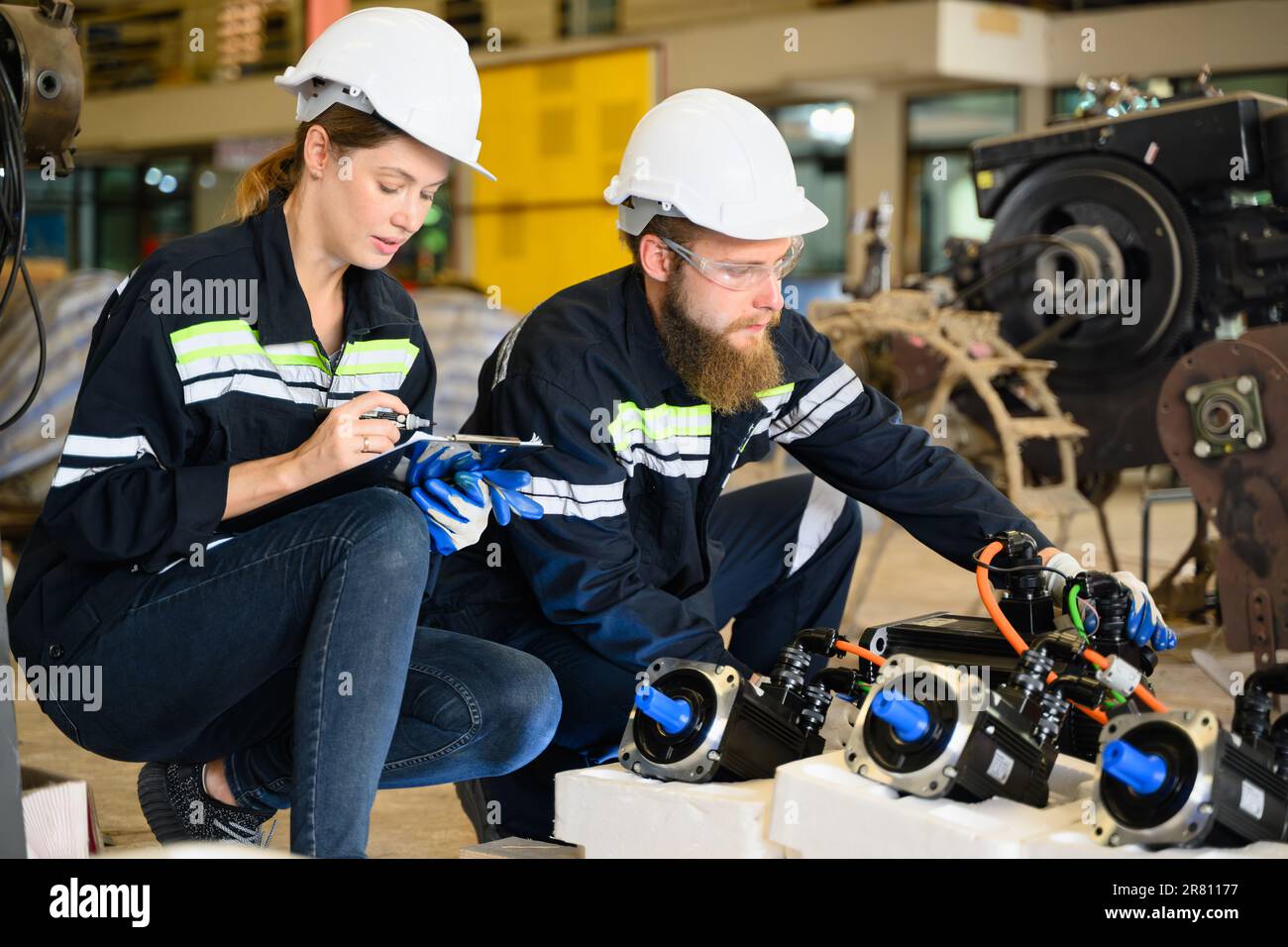Mechanical engineers repairing engine machine at factory Stock Photo ...