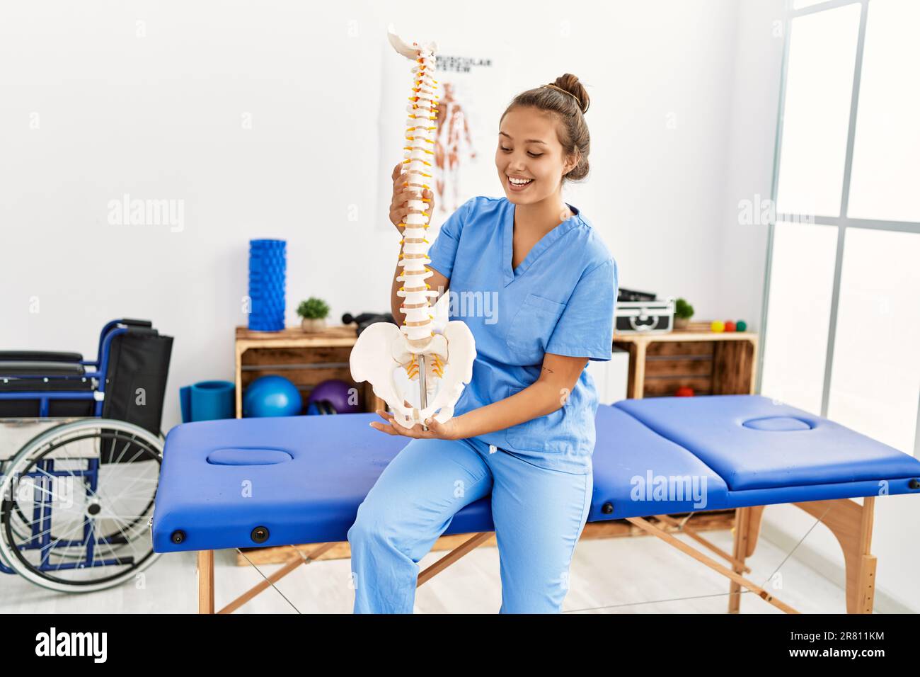 Young beautiful hispanic woman physiotherapist smiling confident ...