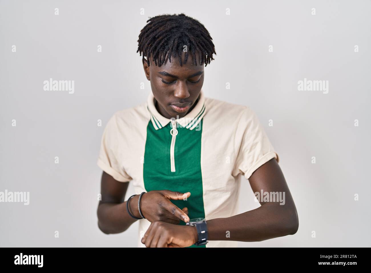African man with dreadlocks standing over isolated background checking ...