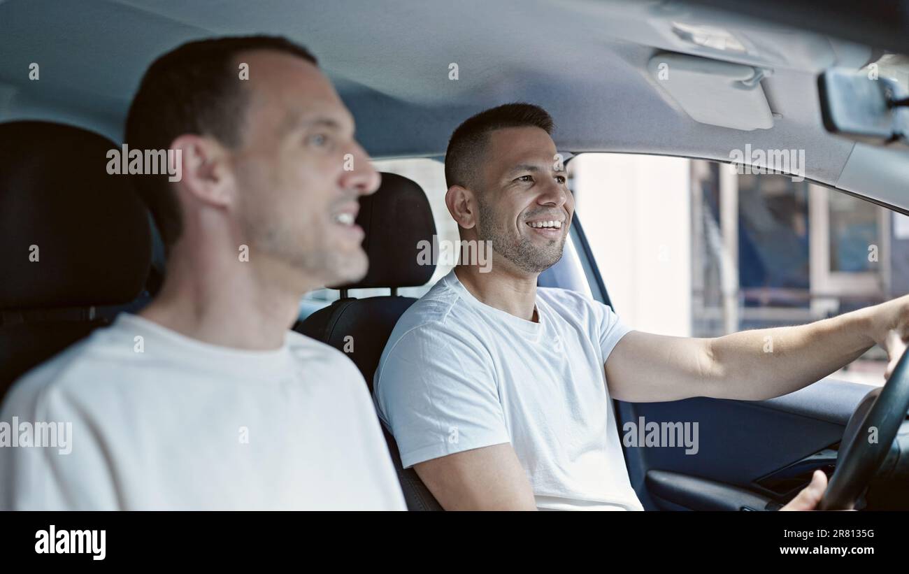 Two men couple driving car speaking at street Stock Photo - Alamy