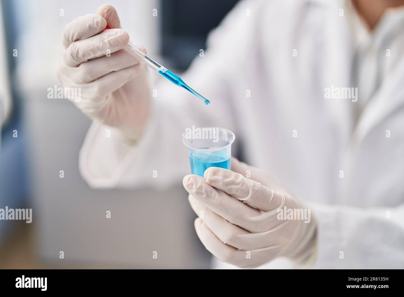 Young hispanic man scientist measuring liquid at laboratory Stock Photo ...