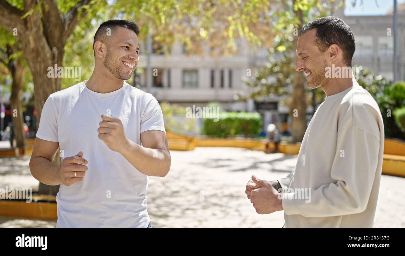 Two men couple smiling confident dancing together at park Stock Photo ...