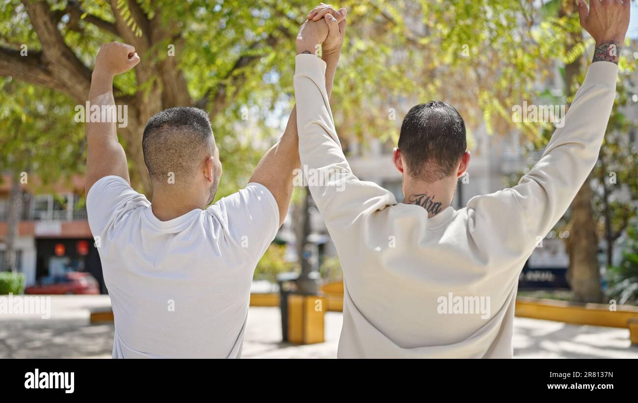 Two men couple with hands together raised up at park Stock Photo - Alamy