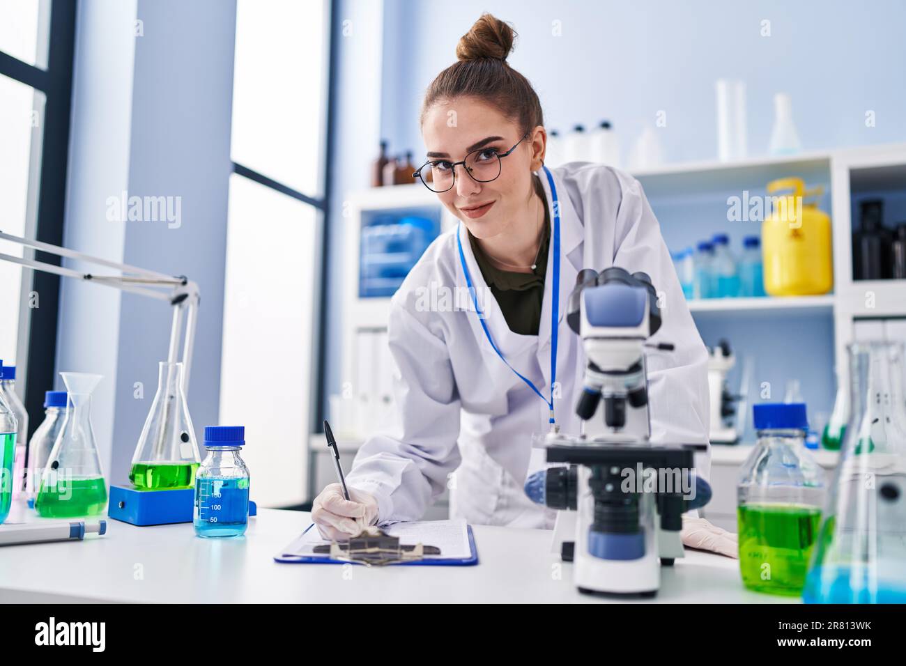 Young woman scientist writing on clipboard at laboratory Stock Photo - Alamy