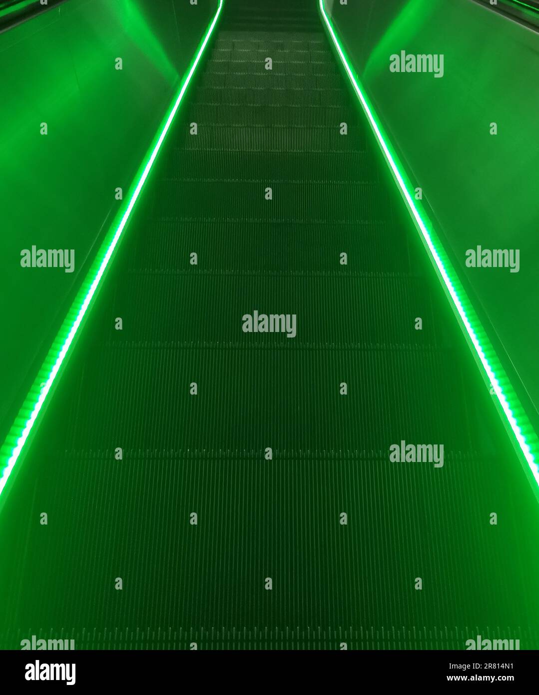 An escalator with a modern design featuring a glowing LED light Stock ...
